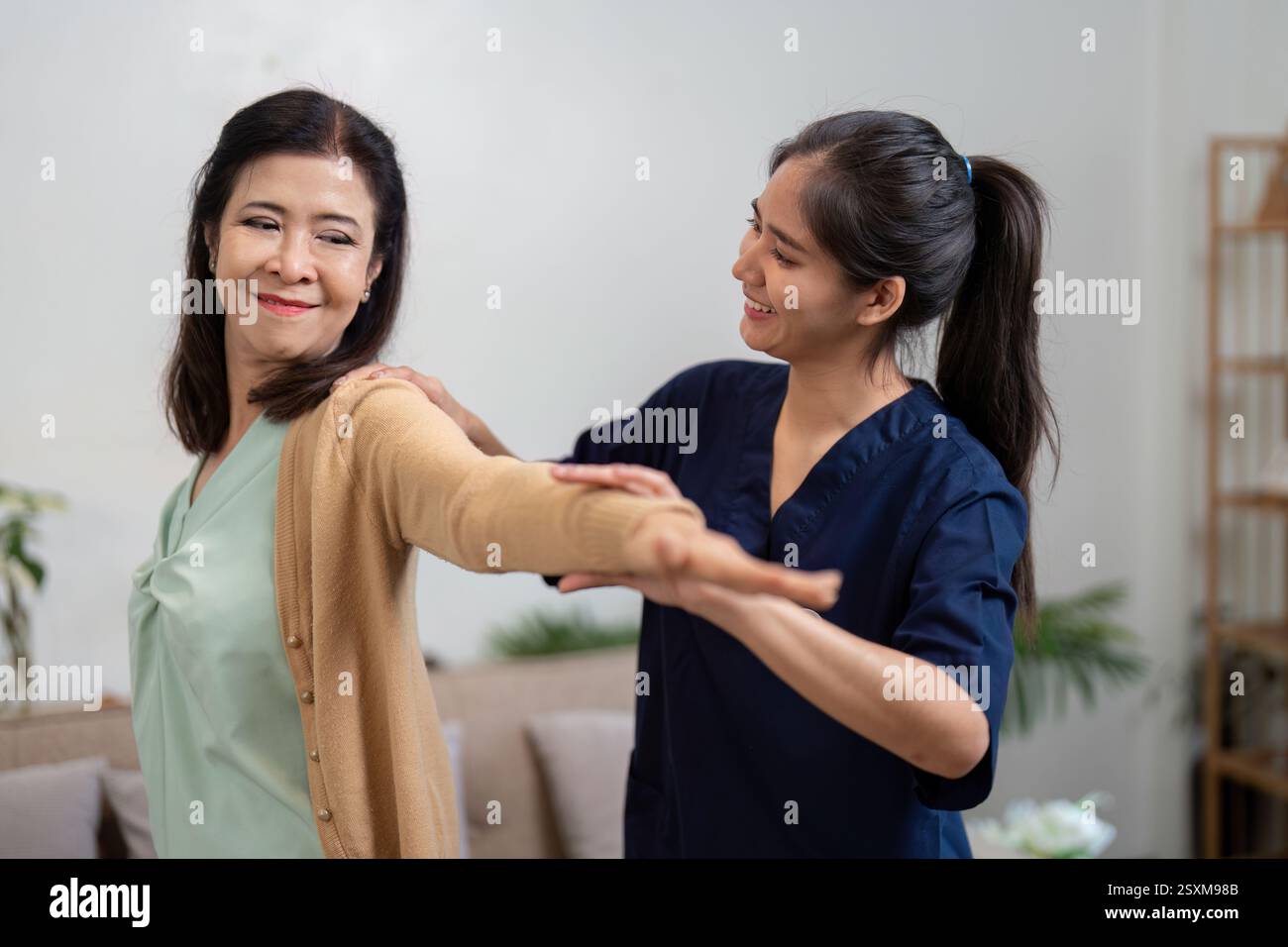 Caregiver assisting elderly patient with mobility exercises, promoting ...