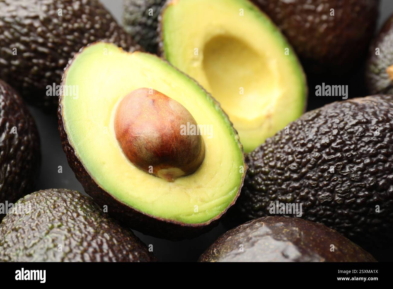 Many whole and cut ripe avocados as background, closeup Stock Photo - Alamy