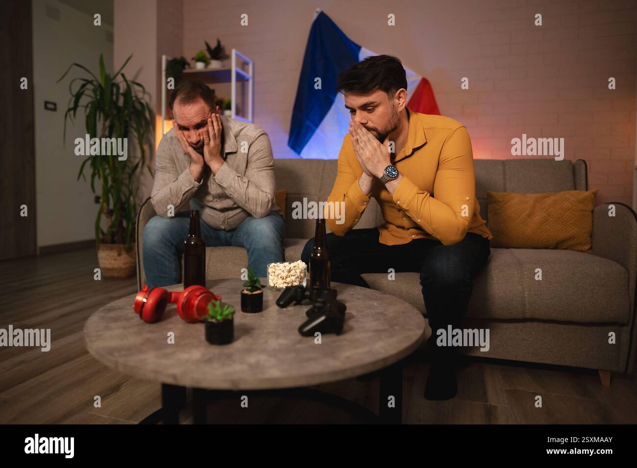 Friends share a tense moment during a competitive gaming night at home ...