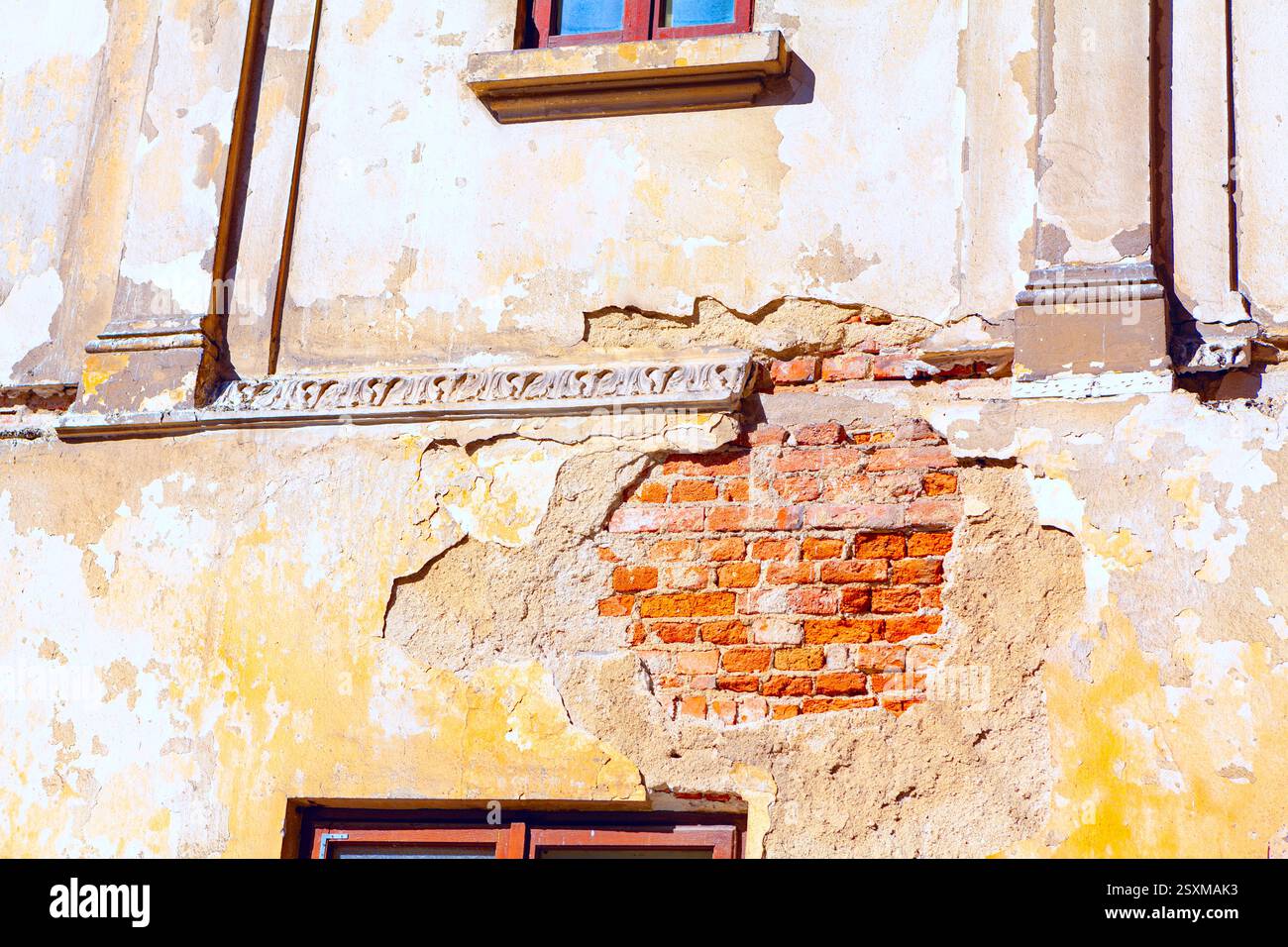 Section of an old deteriorating building facade with visible damage ...