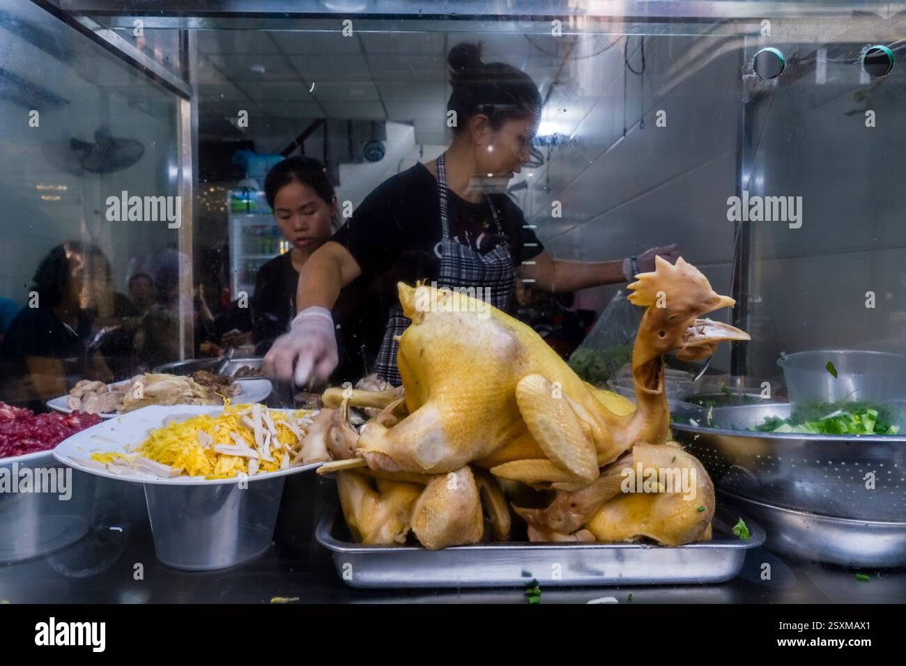 A women sells boiled chicken at one of the many street markets in the ...
