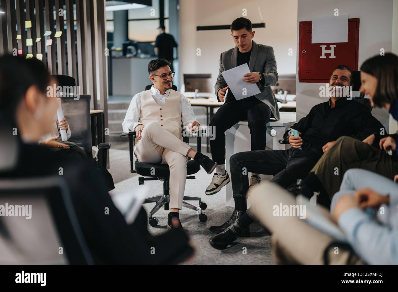 A relaxed group of coworkers sharing ideas in a modern office setting ...