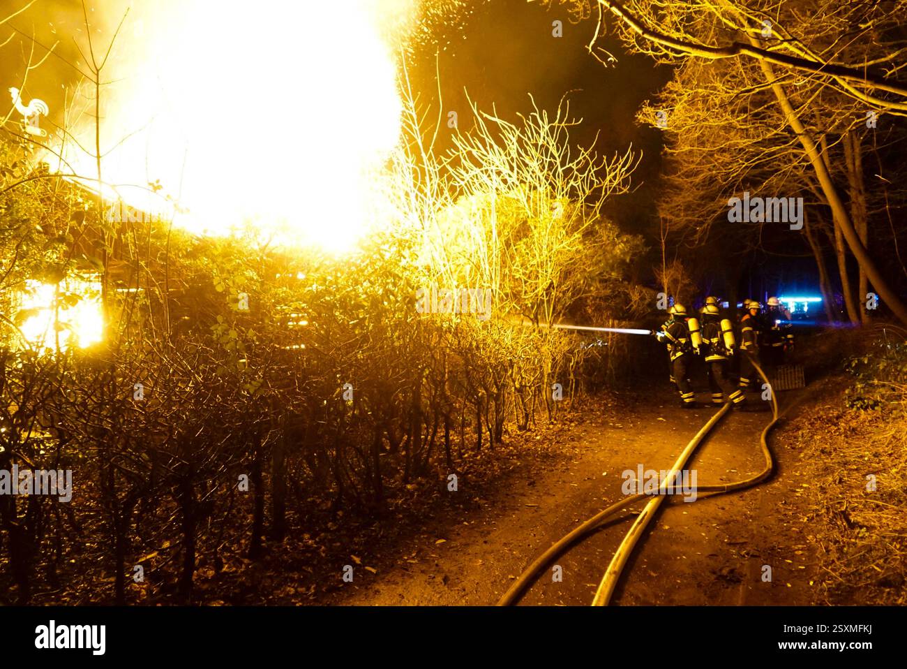 Feuwehrleute im Einsatz beim Loeschen lockerner Flammen beim Vollbrand ...