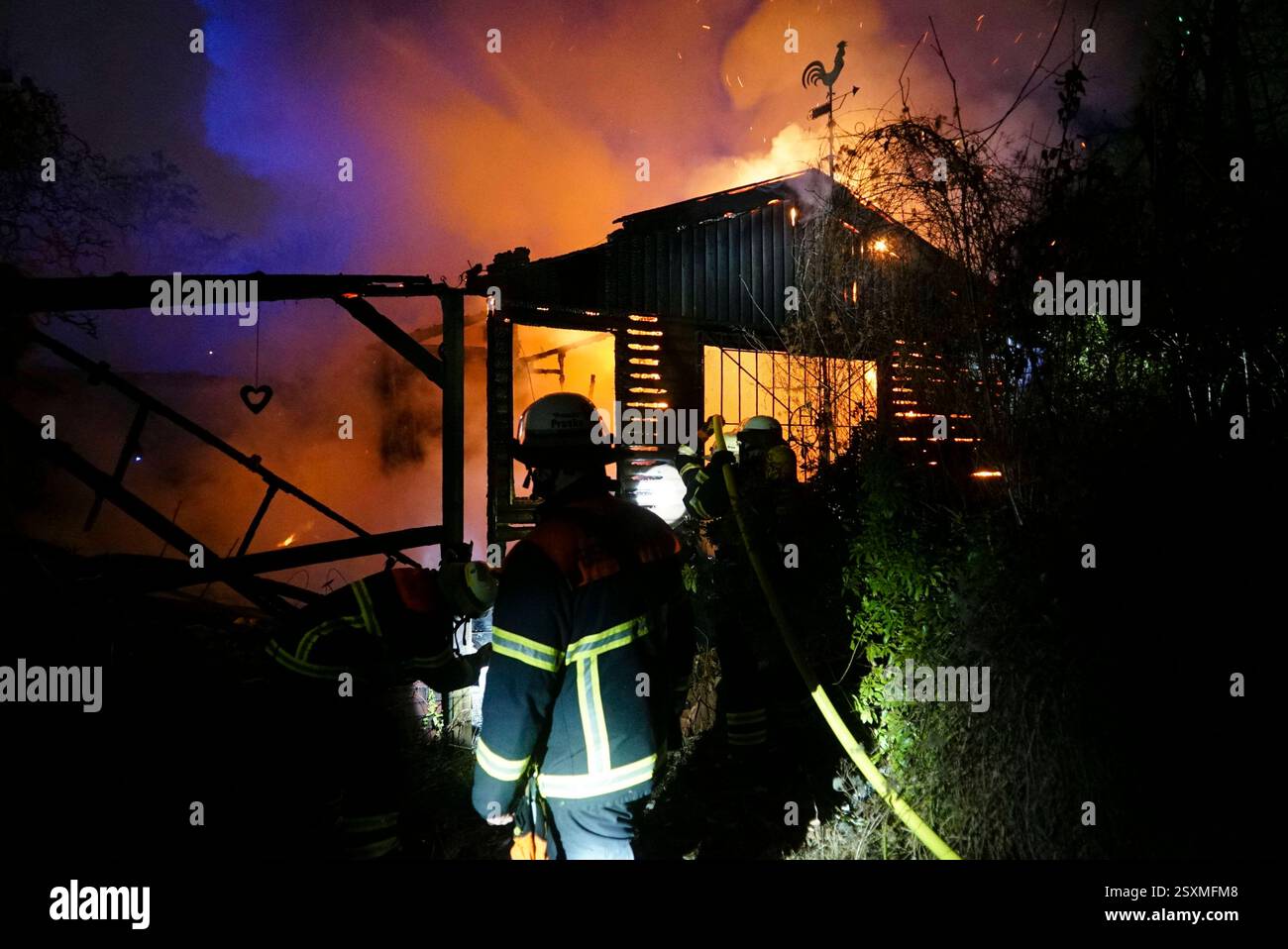 Feuwehrleute im Einsatz beim Loeschen lockerner Flammen beim Vollbrand ...