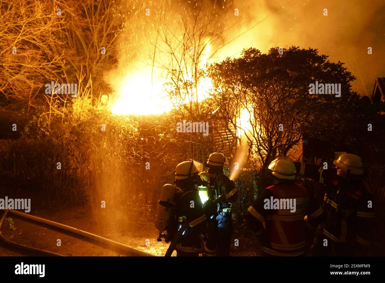 Feuwehrleute im Einsatz beim Loeschen lockerner Flammen beim Vollbrand ...