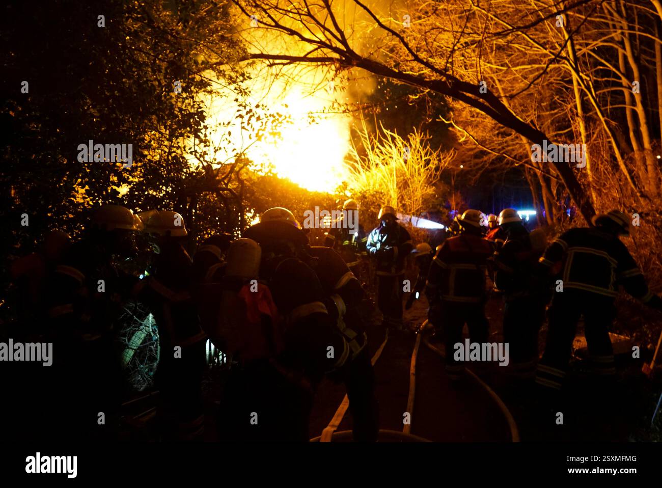 Feuwehrleute im Einsatz beim Loeschen lockerner Flammen beim Vollbrand ...