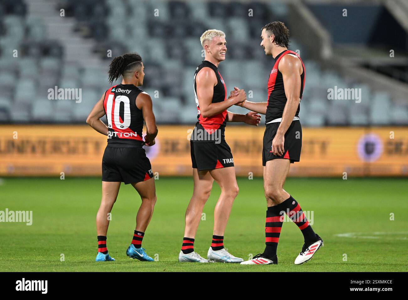 Geelong, Australia. 25th Feb, 2025. Nate Caddy of Essendon (centre) and ...
