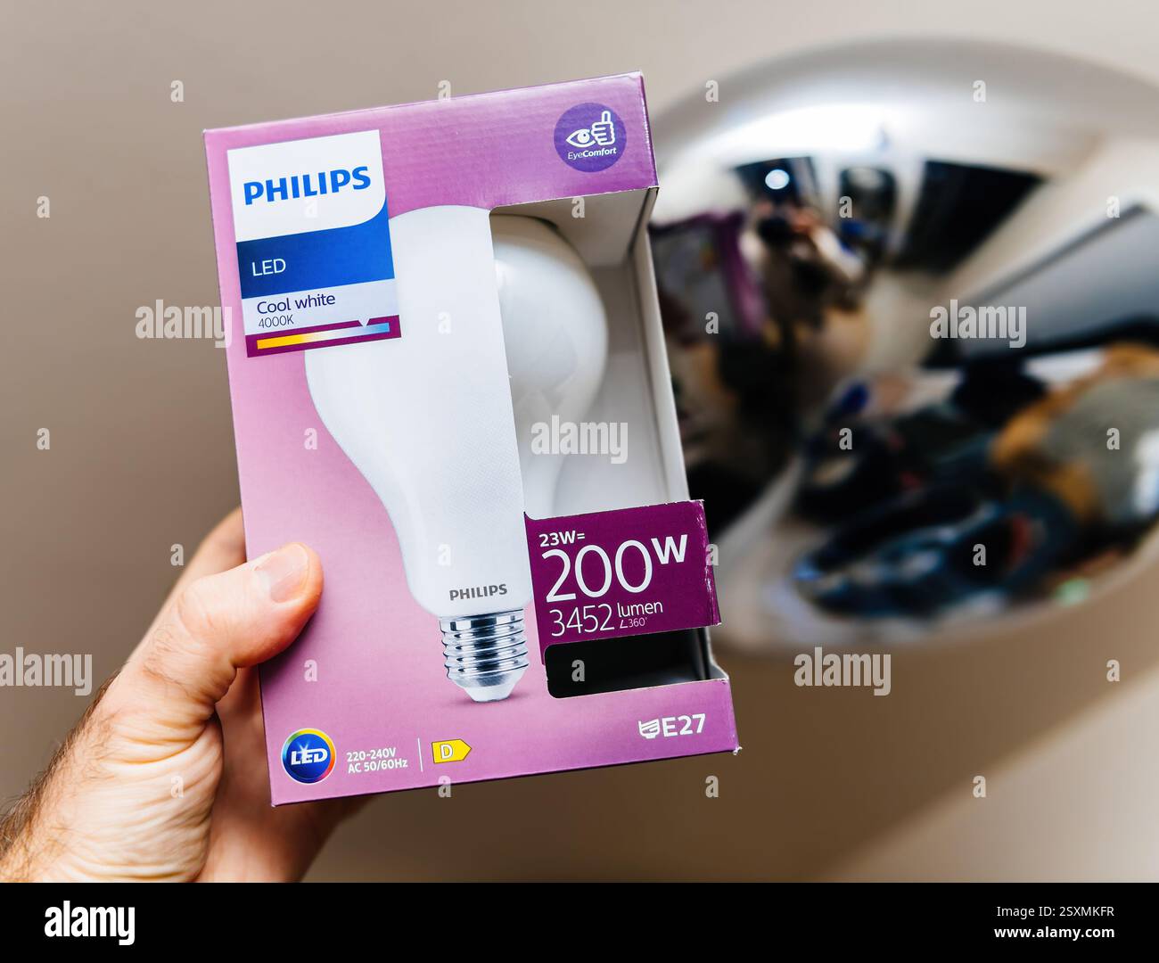 Paris, France - Feb 17, 2025: person holds a Philips LED cool white ...