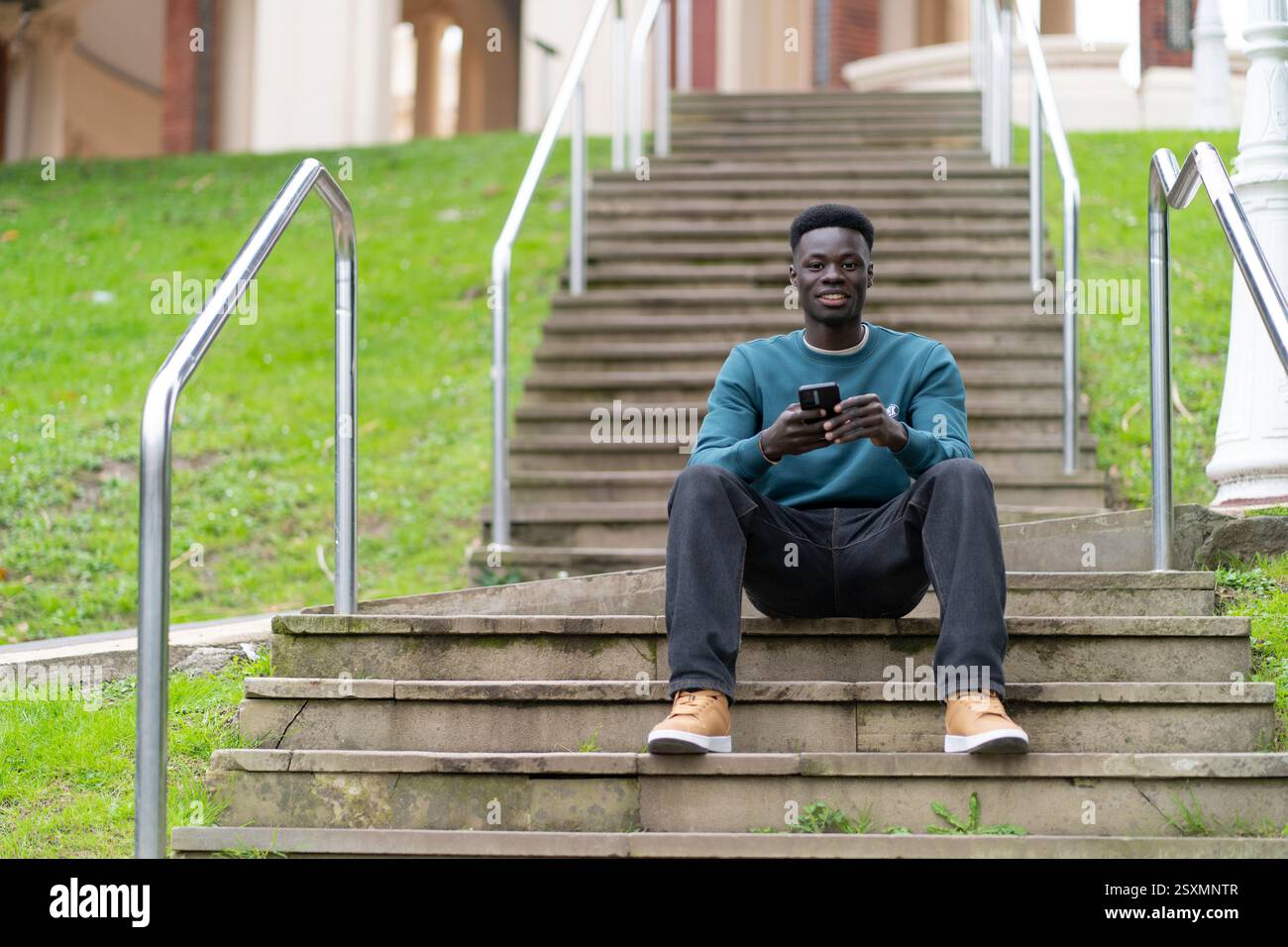 Happy african american college student using mobile phone app sitting ...