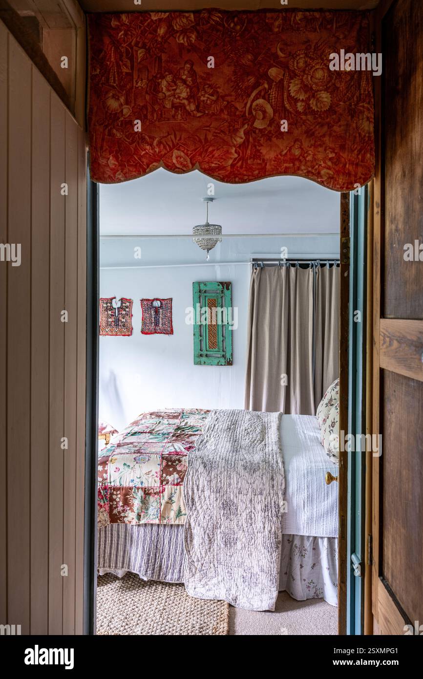 Antique fabric with patchwork quilt on bed in Chalford weavers cottage ...
