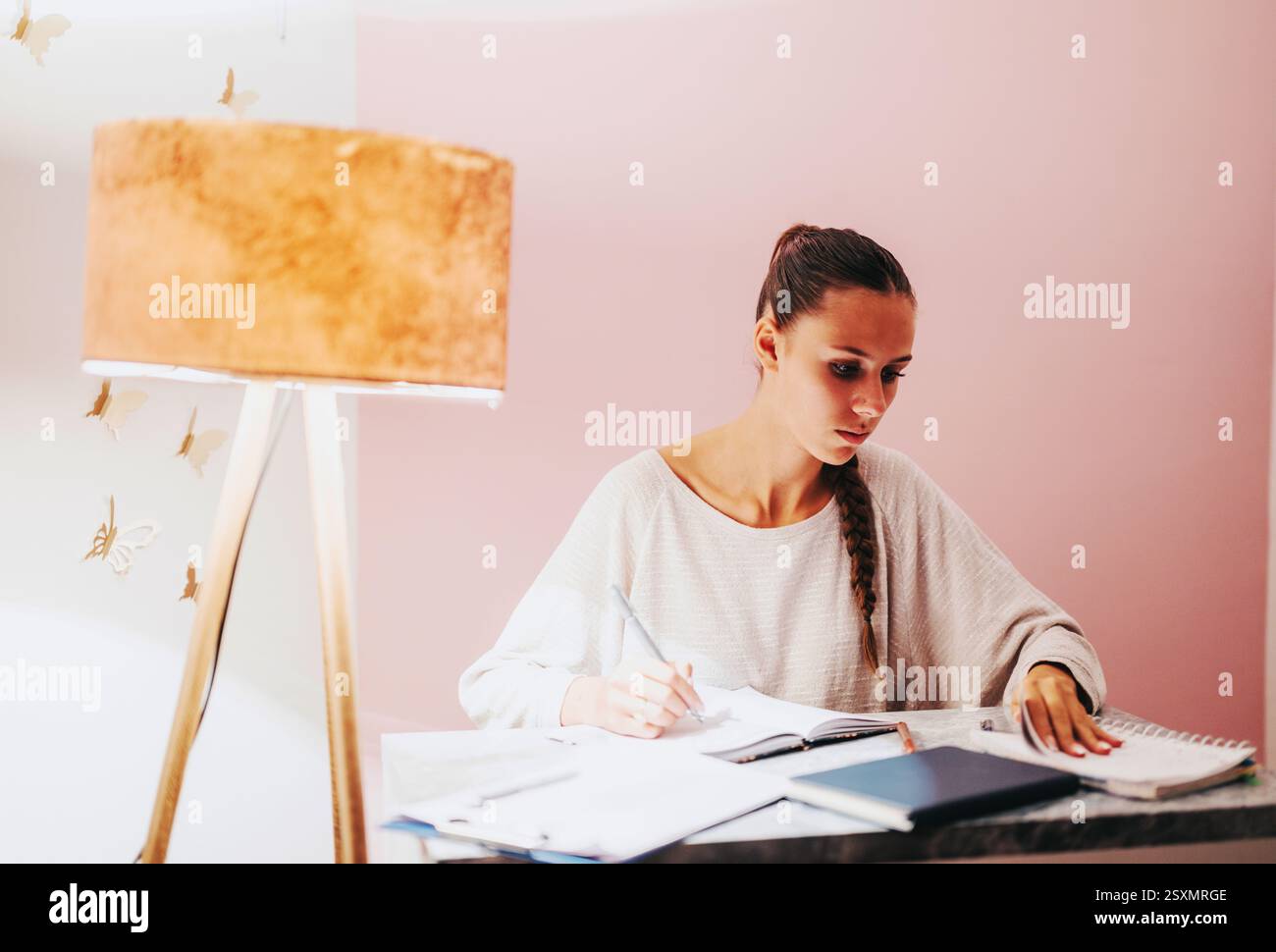 Focused college student studying at home under warm lighting Stock ...