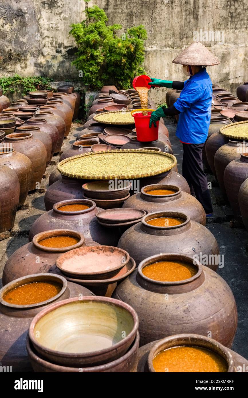 Soy sauce is made in large earthenware pots in a backyard in the small ...