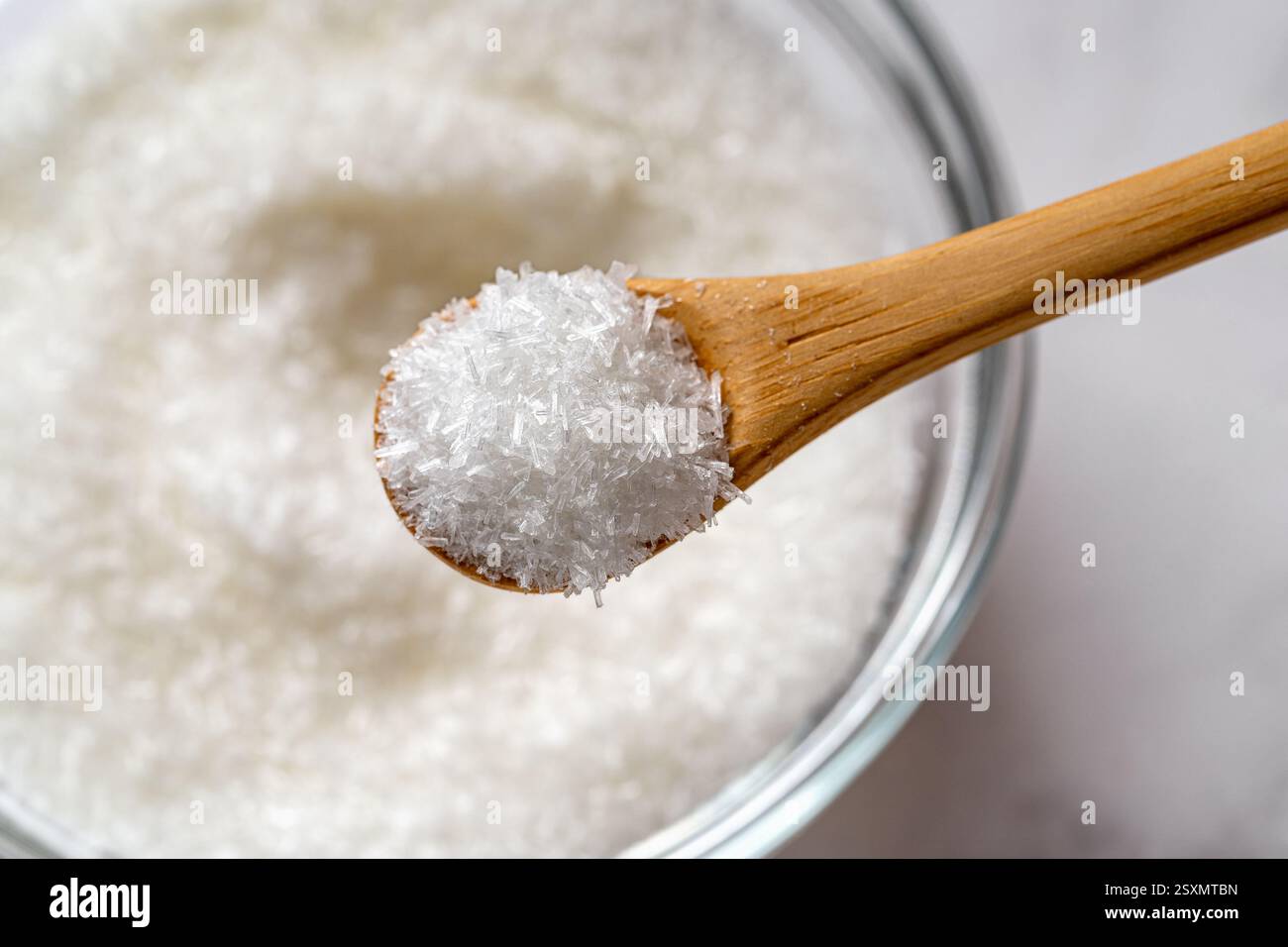 Wooden spoon full of monosodium glutamate over MSG white crystals in a ...