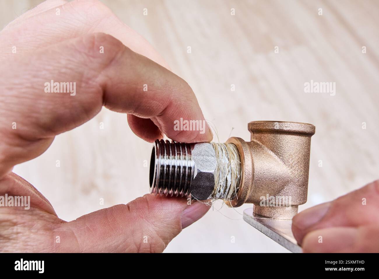 Hex nipple barrel reducer adapter is being sealed with plumbing hemp ...