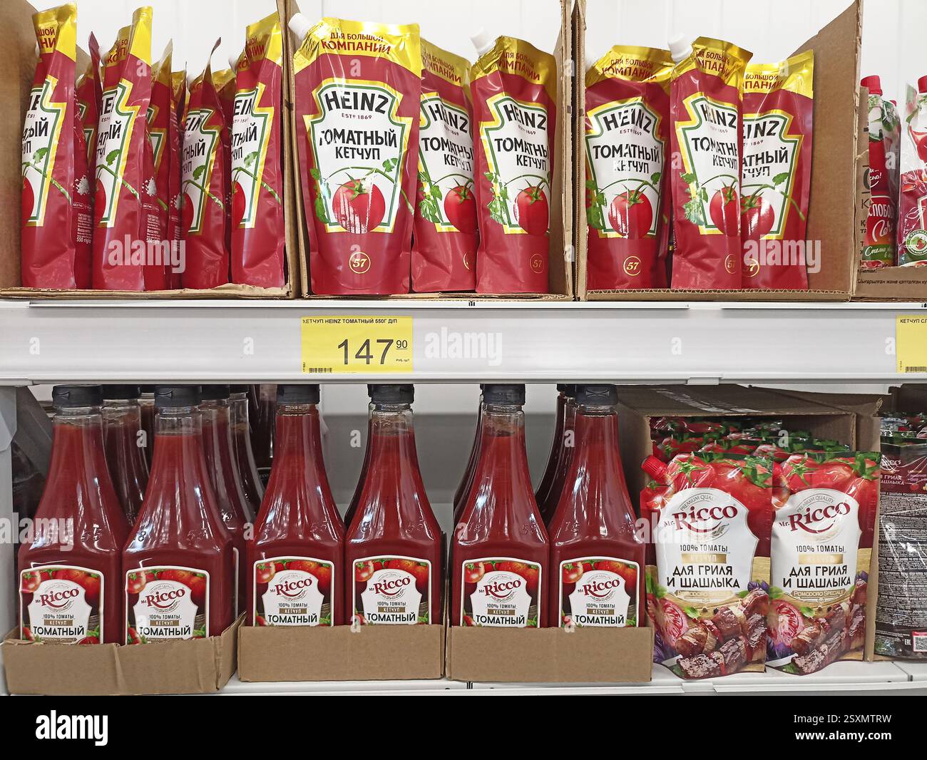 Variety of ketchup brands on supermarket shelf with labels and prices ...