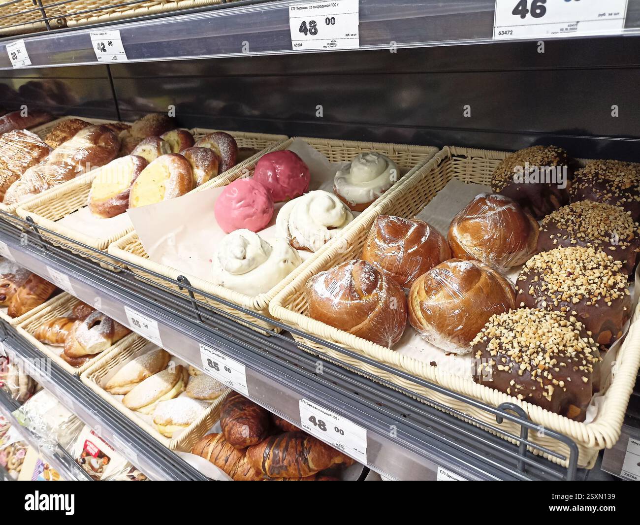 Assorted pastries displayed on bakery shelves in a store Stock Photo ...