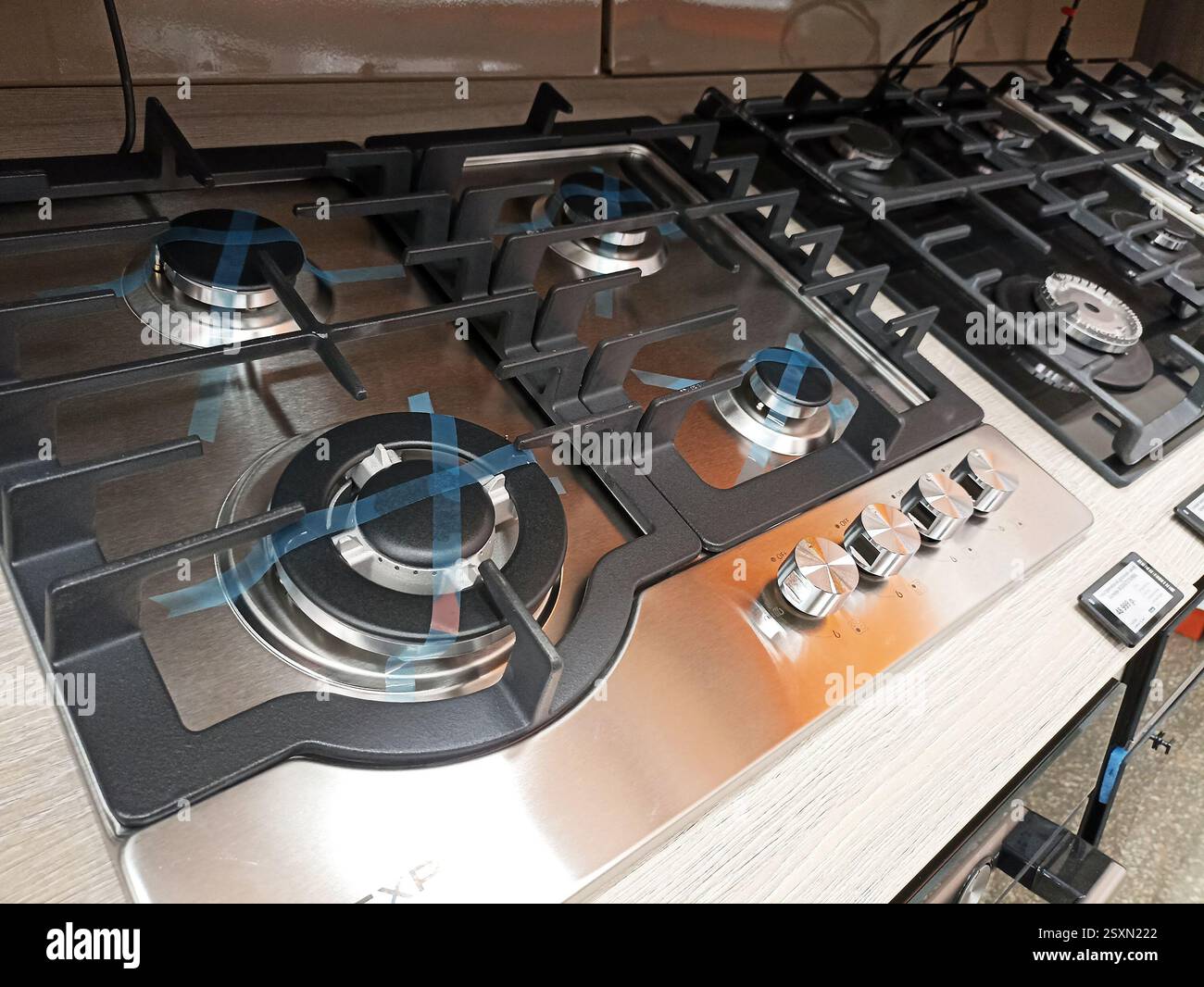 Modern stainless steel gas stove with multiple burners and knobs on ...