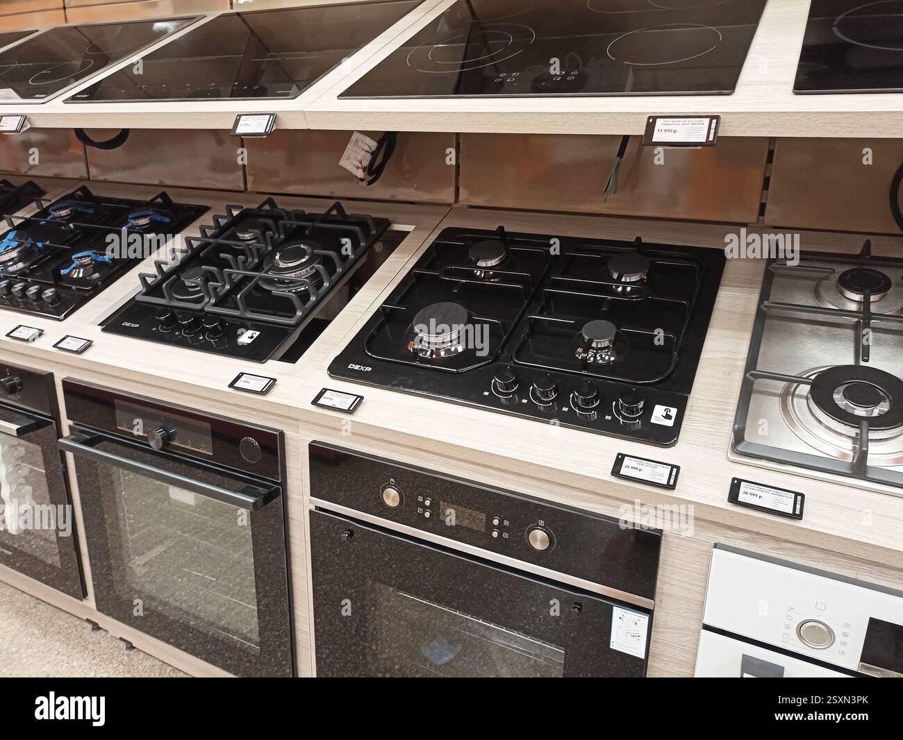 Modern kitchen appliances display with gas and induction stoves Stock ...