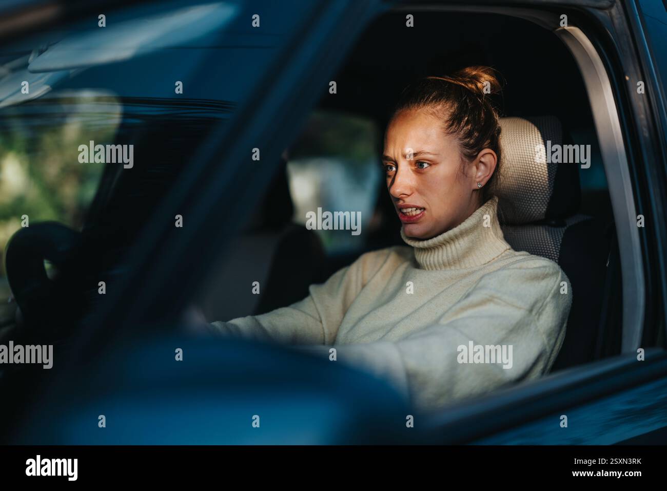Woman driving a car with an expression of frustration and anxiety Stock ...
