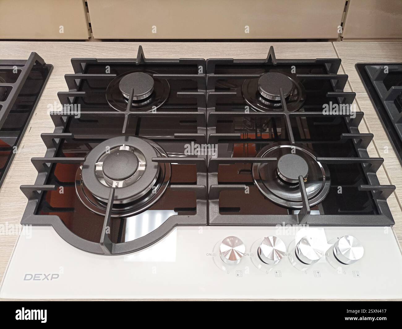 Modern stainless steel gas stove with four burners and control knobs ...