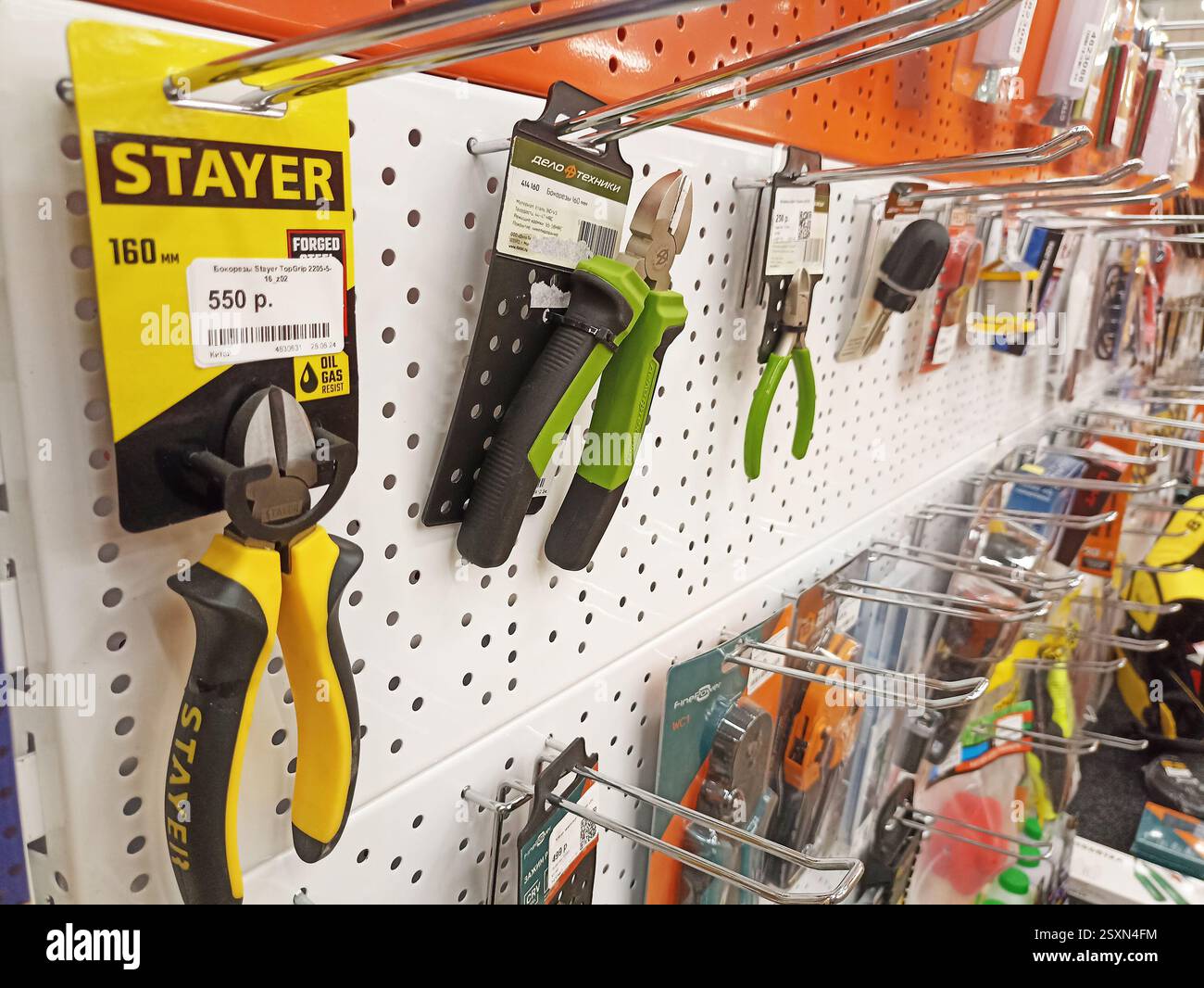 Assorted handheld tools displayed on pegboard in hardware store Stock ...
