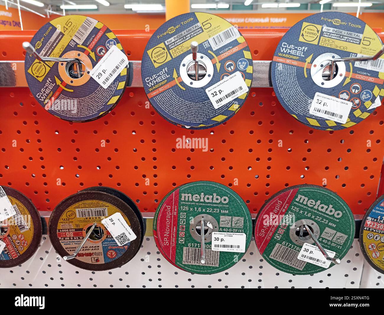 Assorted metal cutting discs display on orange pegboard in hardware ...