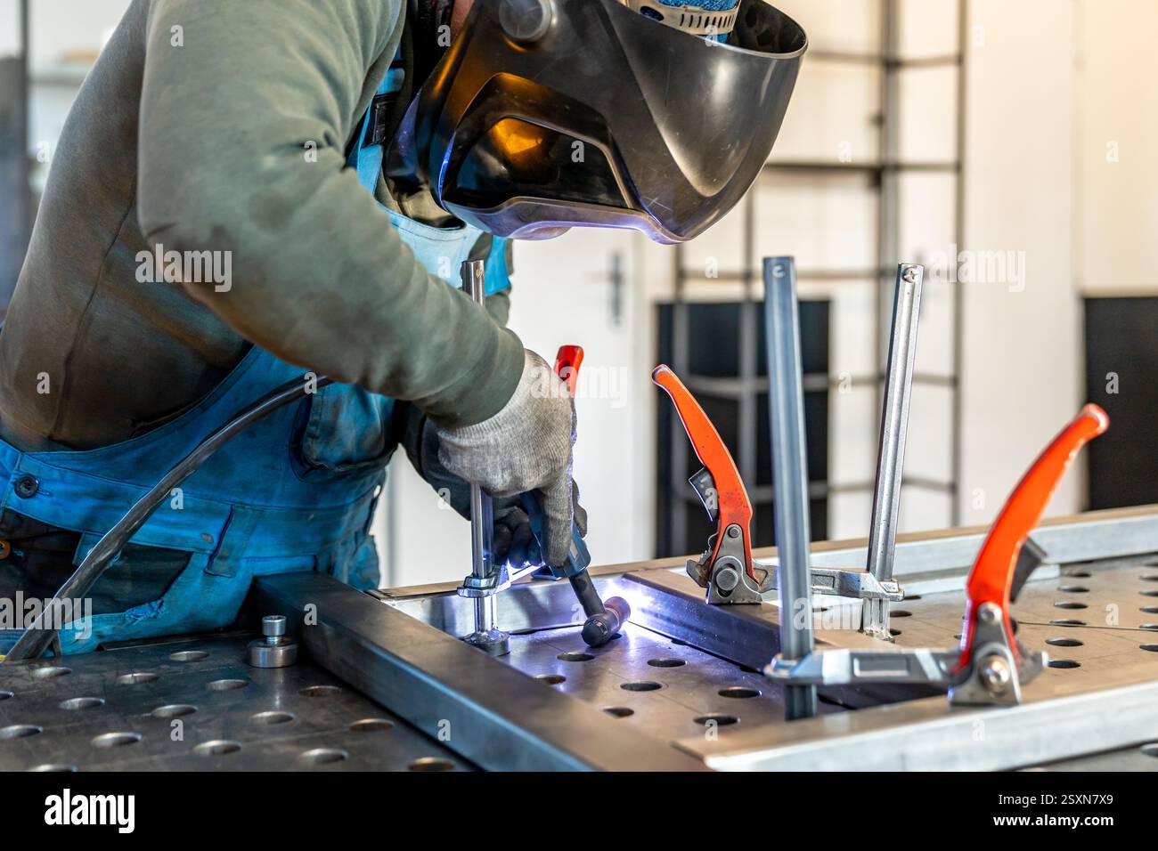 Welder joining metal parts using welding torch in workshop Stock Photo ...
