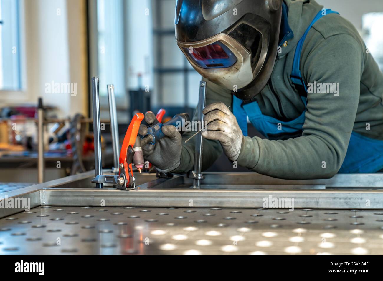 Welder joining metal parts using tungsten inert gas welding process ...