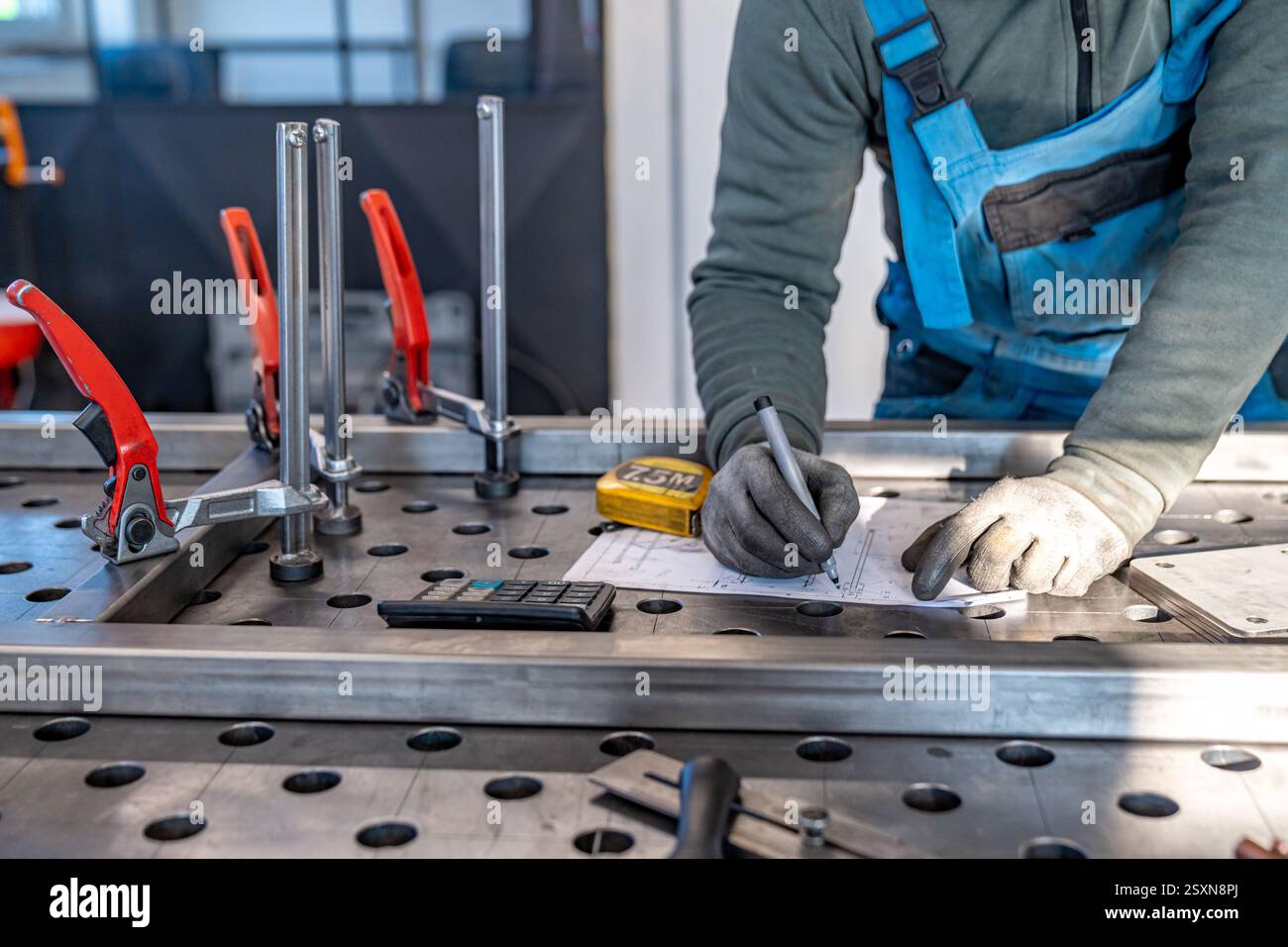 Metalworker drawing lines on blueprint using pen in workshop Stock ...