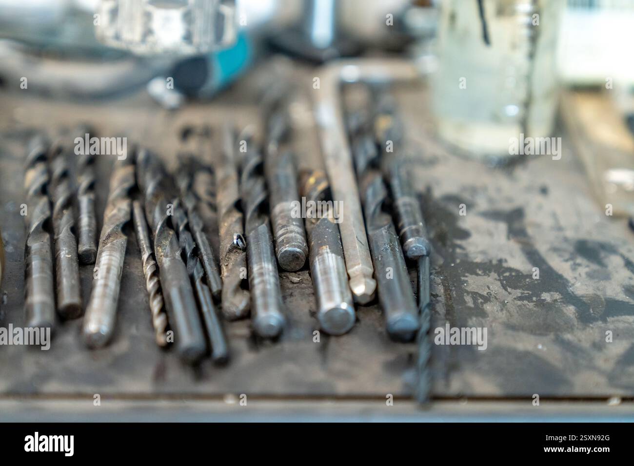 Drill bits and hex key lying on dirty workbench in workshop Stock Photo ...