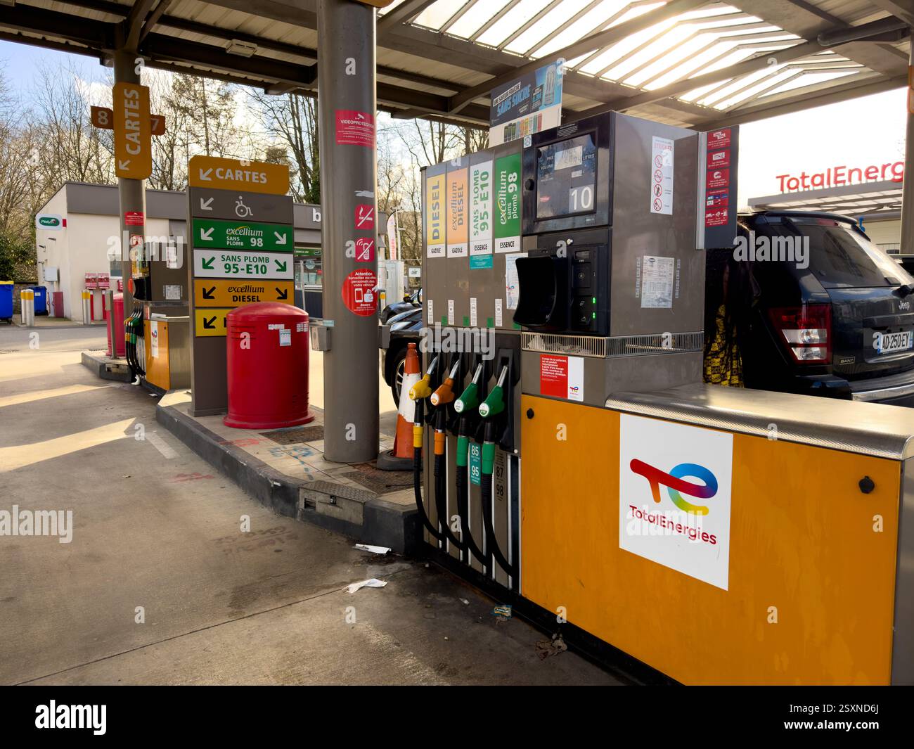 Fueling up at a busy service station on a sunny morning with various ...