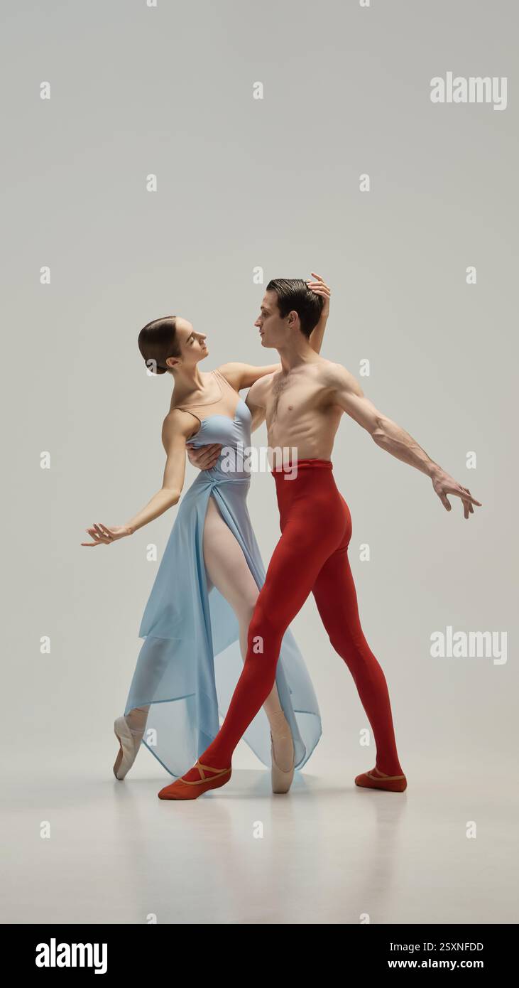 Ballerina, wearing flowing dress, dancing in dramatic extension while ...