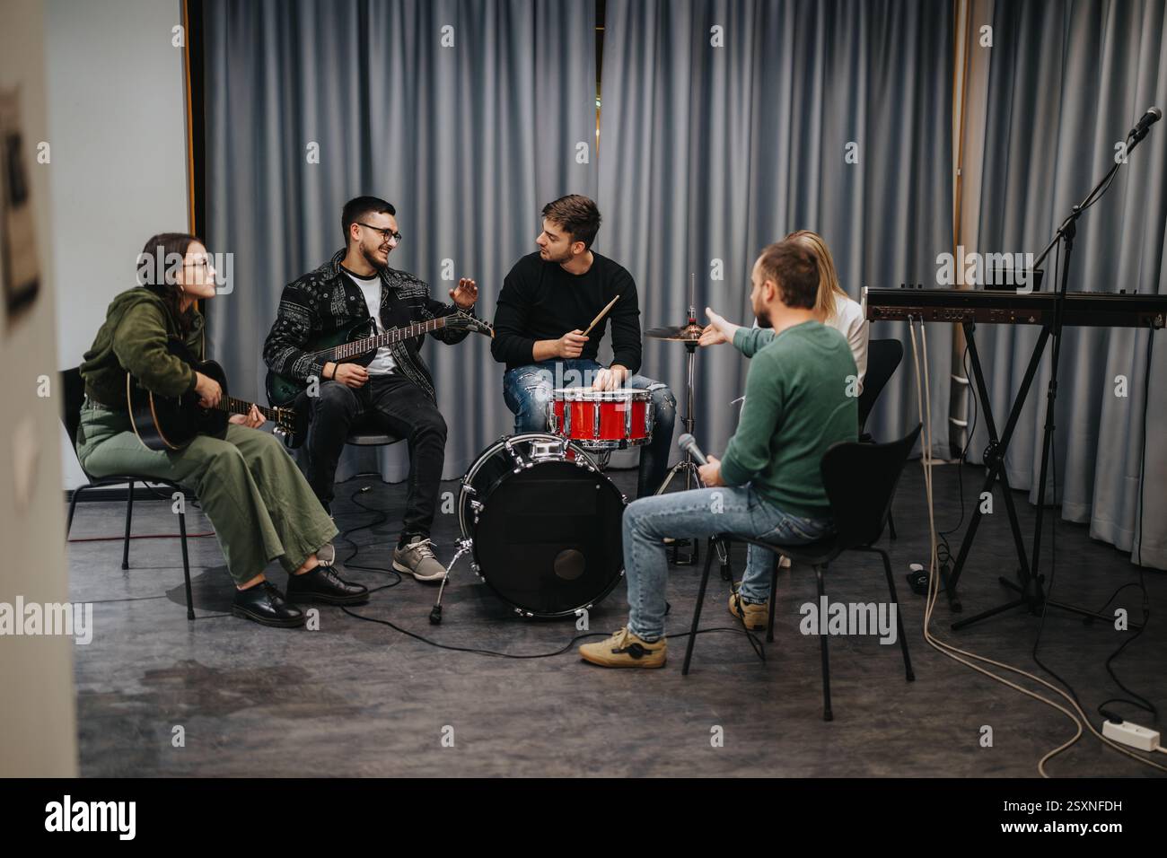 Band rehearsing together and collaborating in a music studio ...
