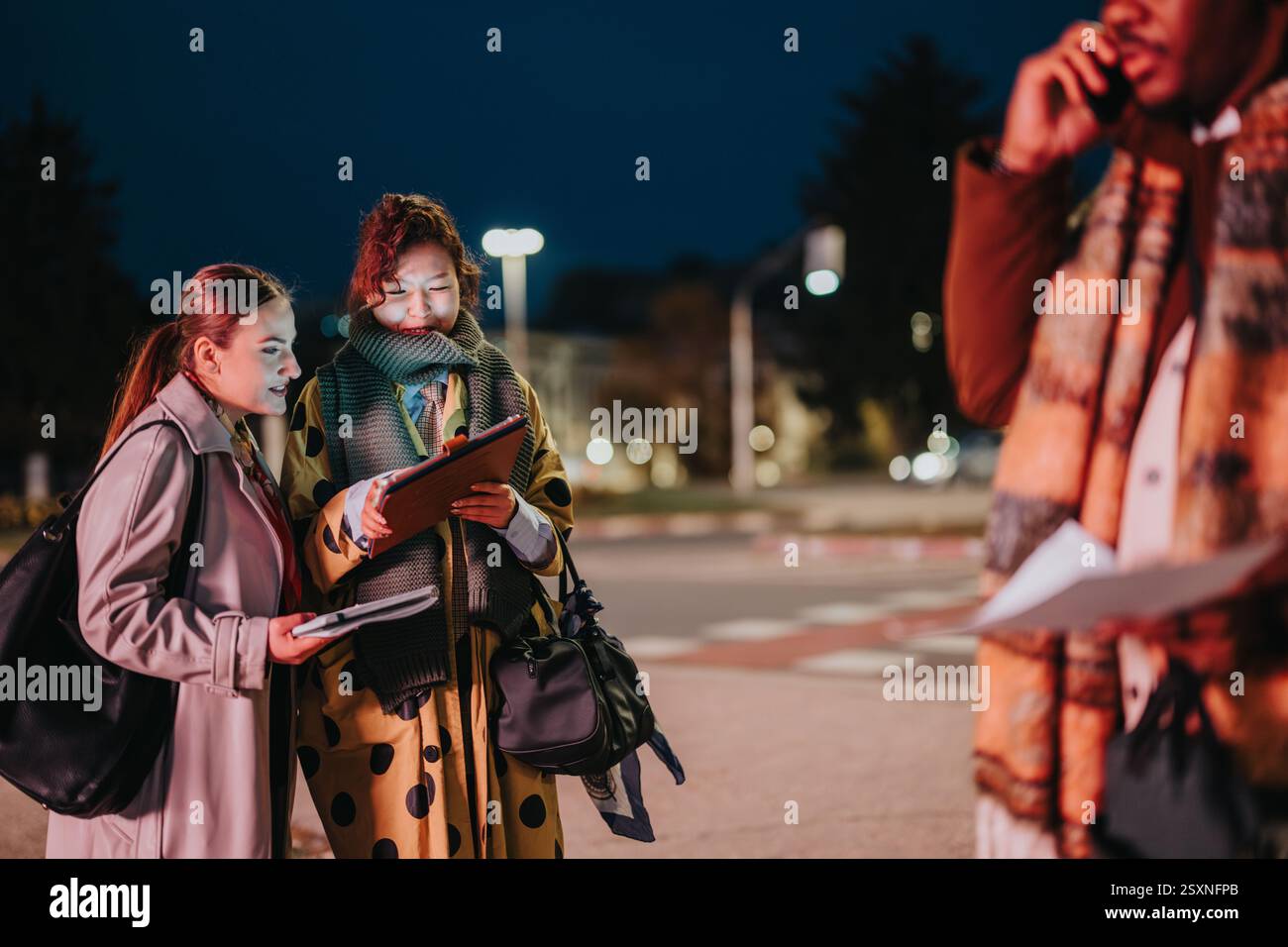 Collaborative group of diverse people reviewing documents outdoors at ...