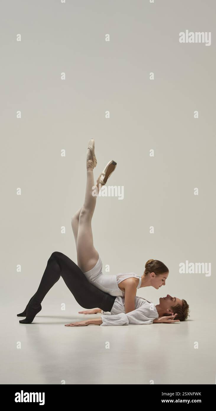 Male and female ballet dancers gracefully moving in tandem while ...