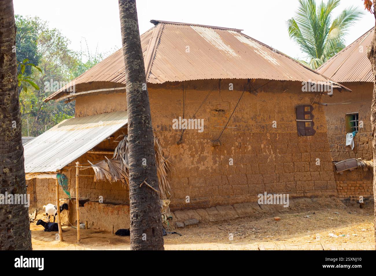 a traditional Indian village mud house with a corrugated metal roof ...