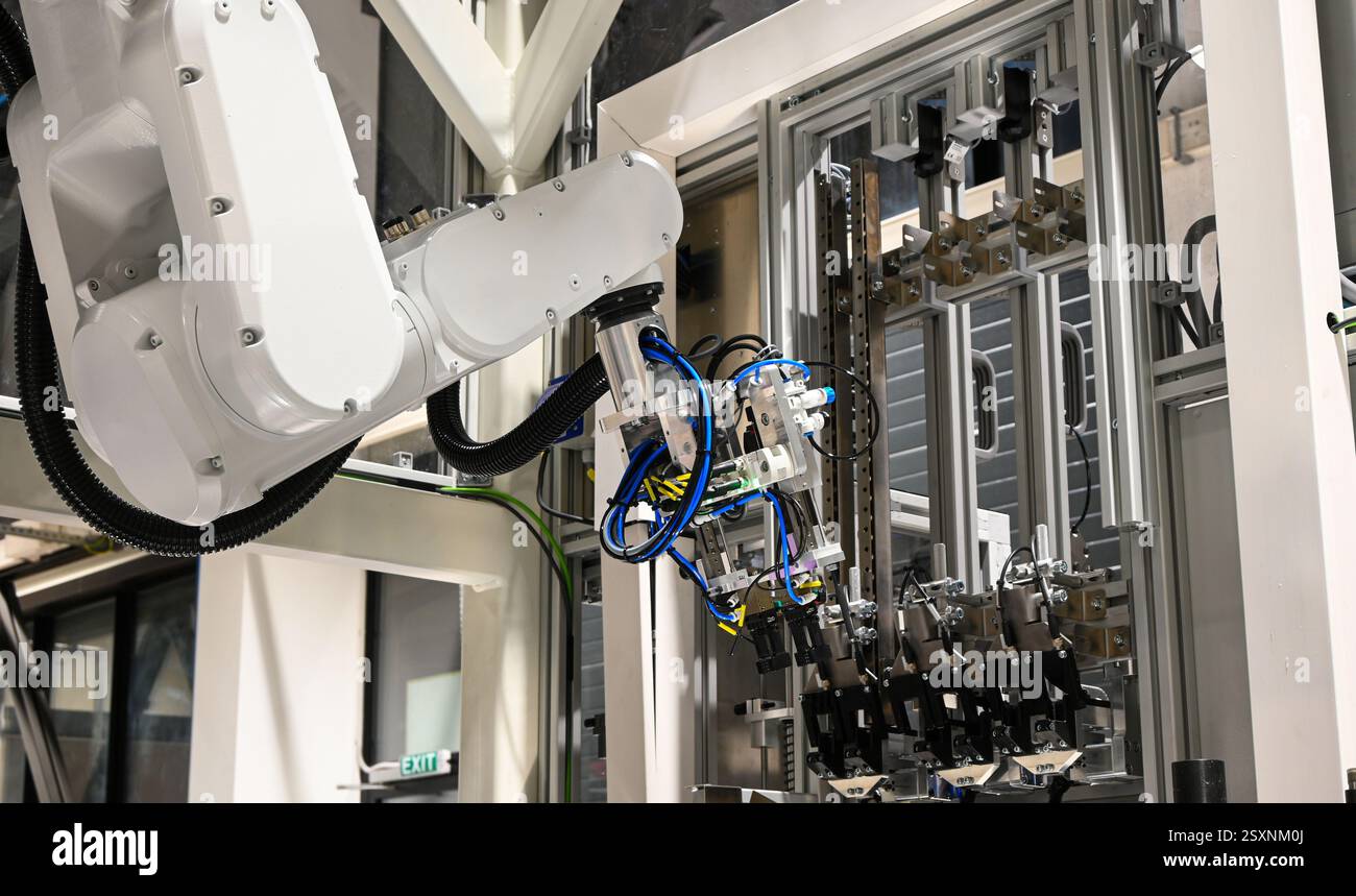 Modern robotic arm performing tasks on an automated production line in a high-tech factory Stock ...