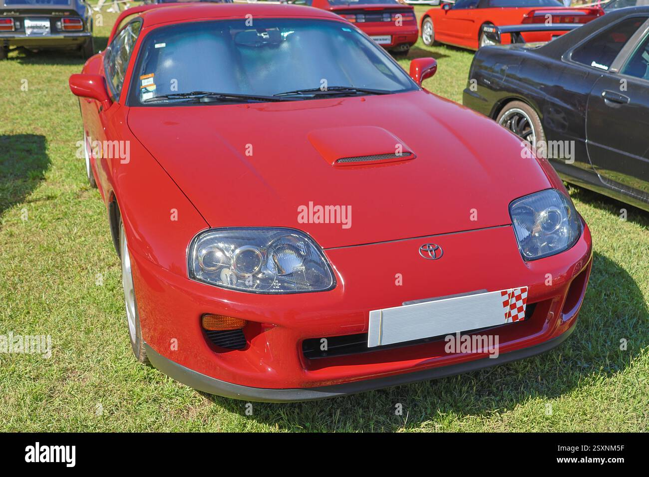 Gleaming red toyota supra parked on grass, showcasing its sporty design ...