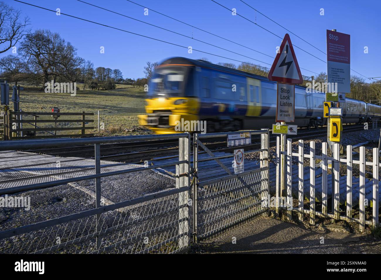 Northern Rail train traveling across unmanned level crossing (trackside ...