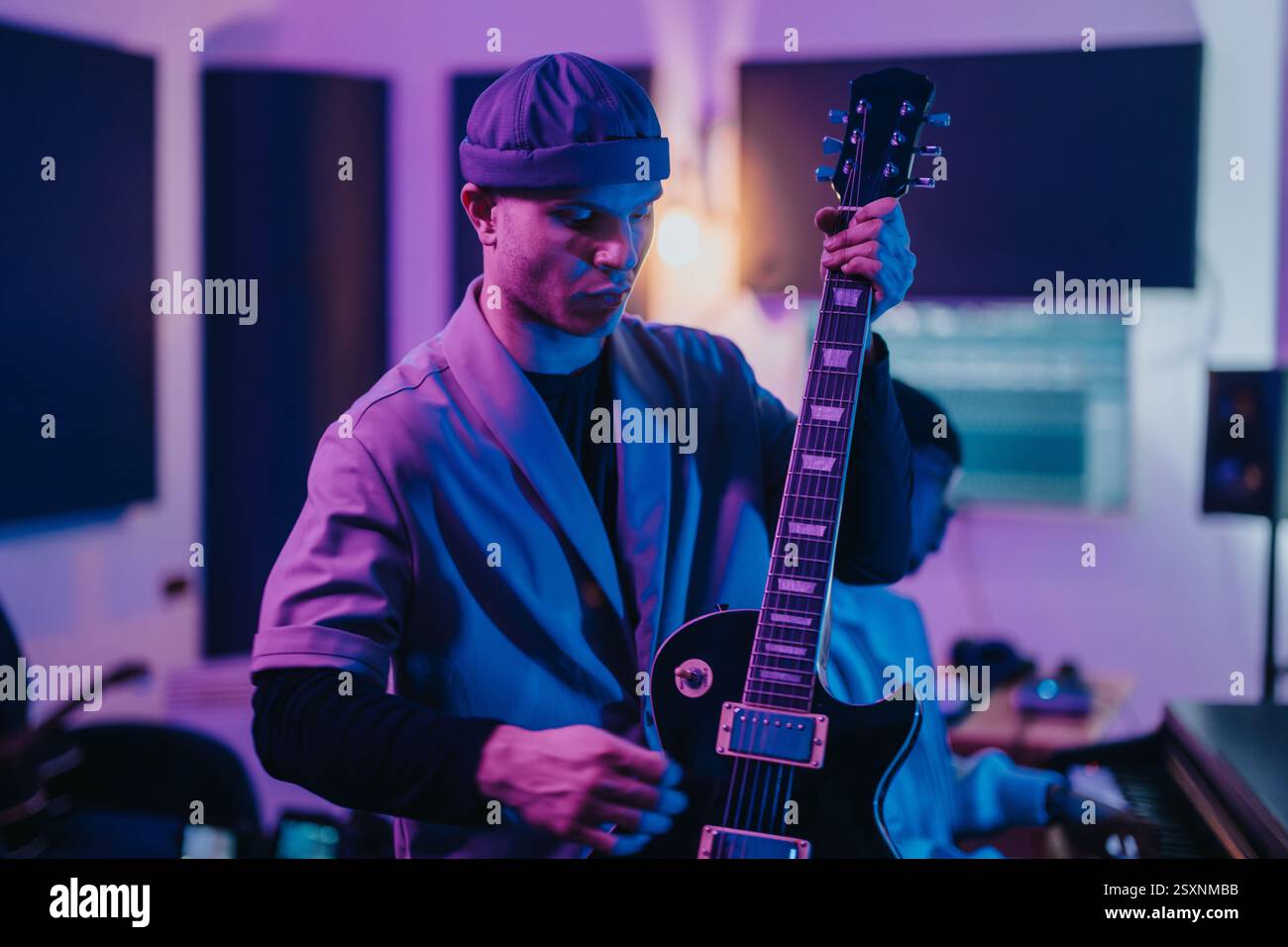 Musicians collaborating in a vibrant studio environment with guitars ...