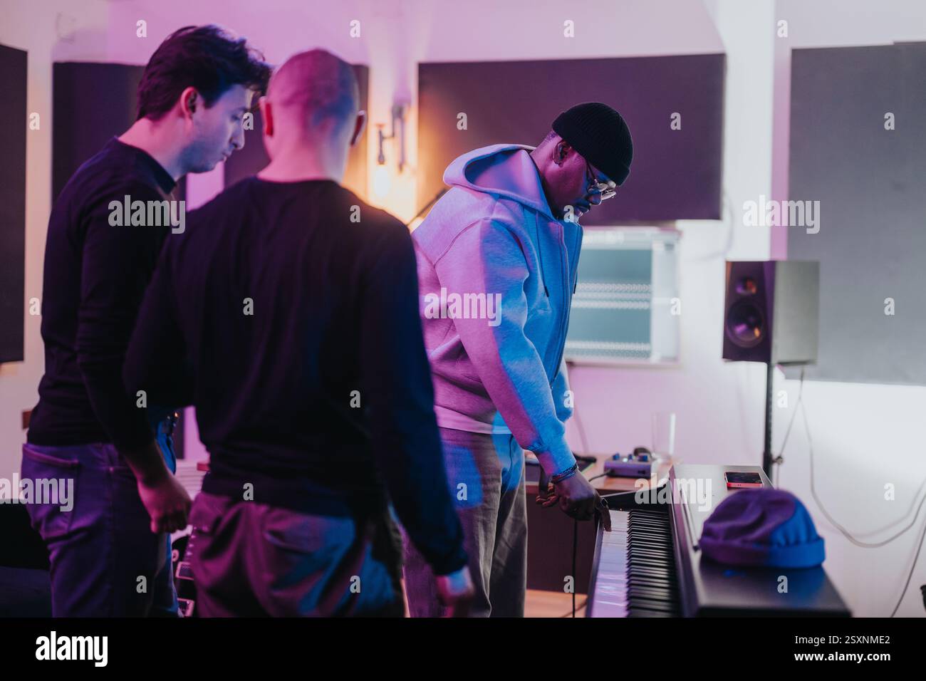 Multiracial musicians collaborating on a project in a modern recording ...