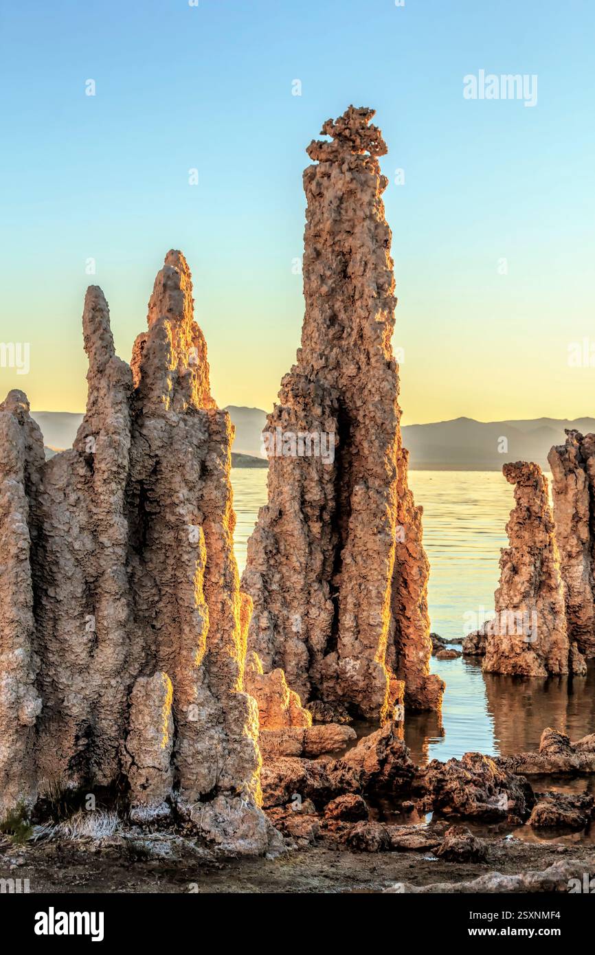 Group of tall rocks are on the shore of a lake. The rocks are white and ...