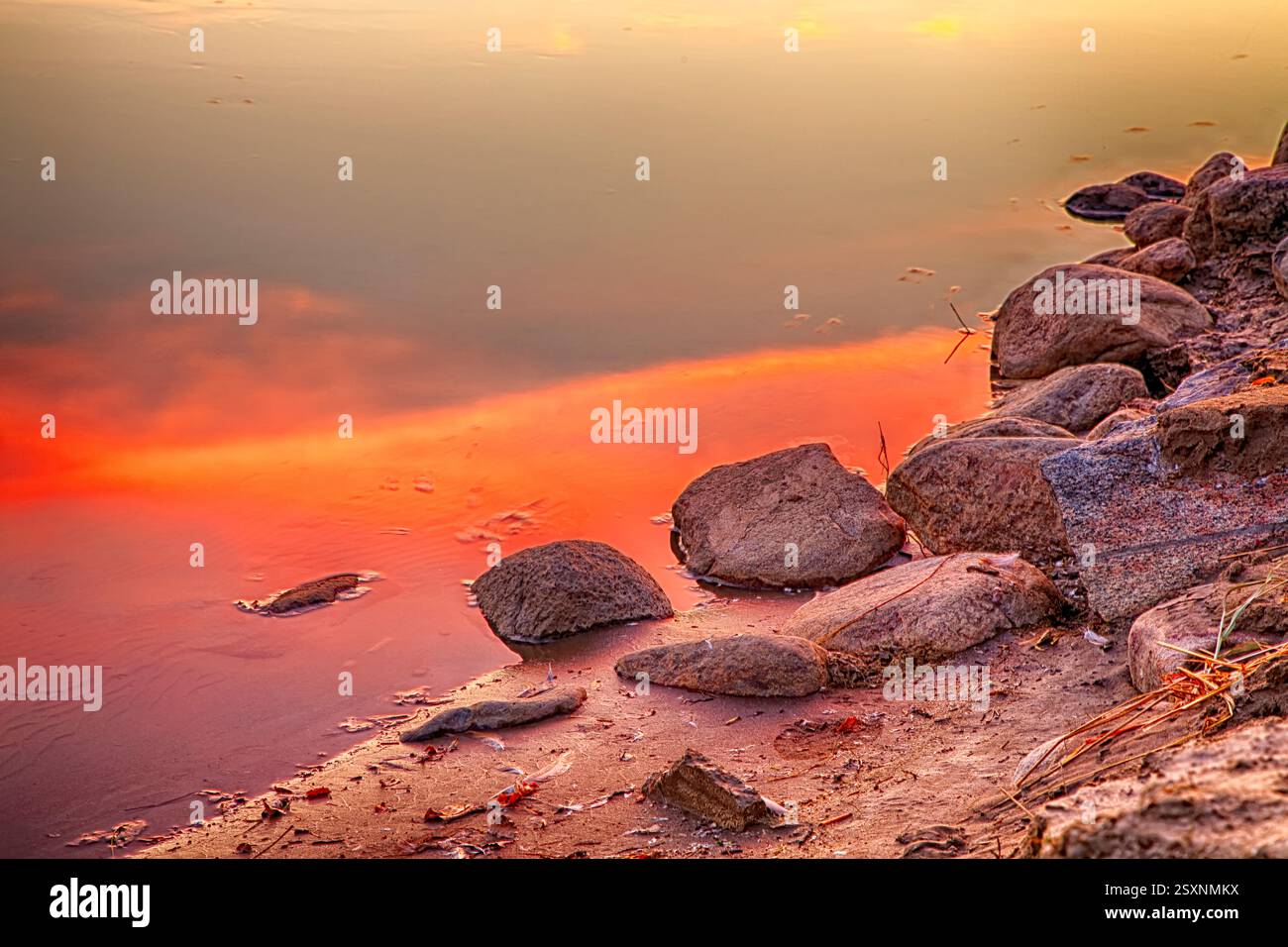 Rocky shoreline with a body of water. The water is a deep blue color ...