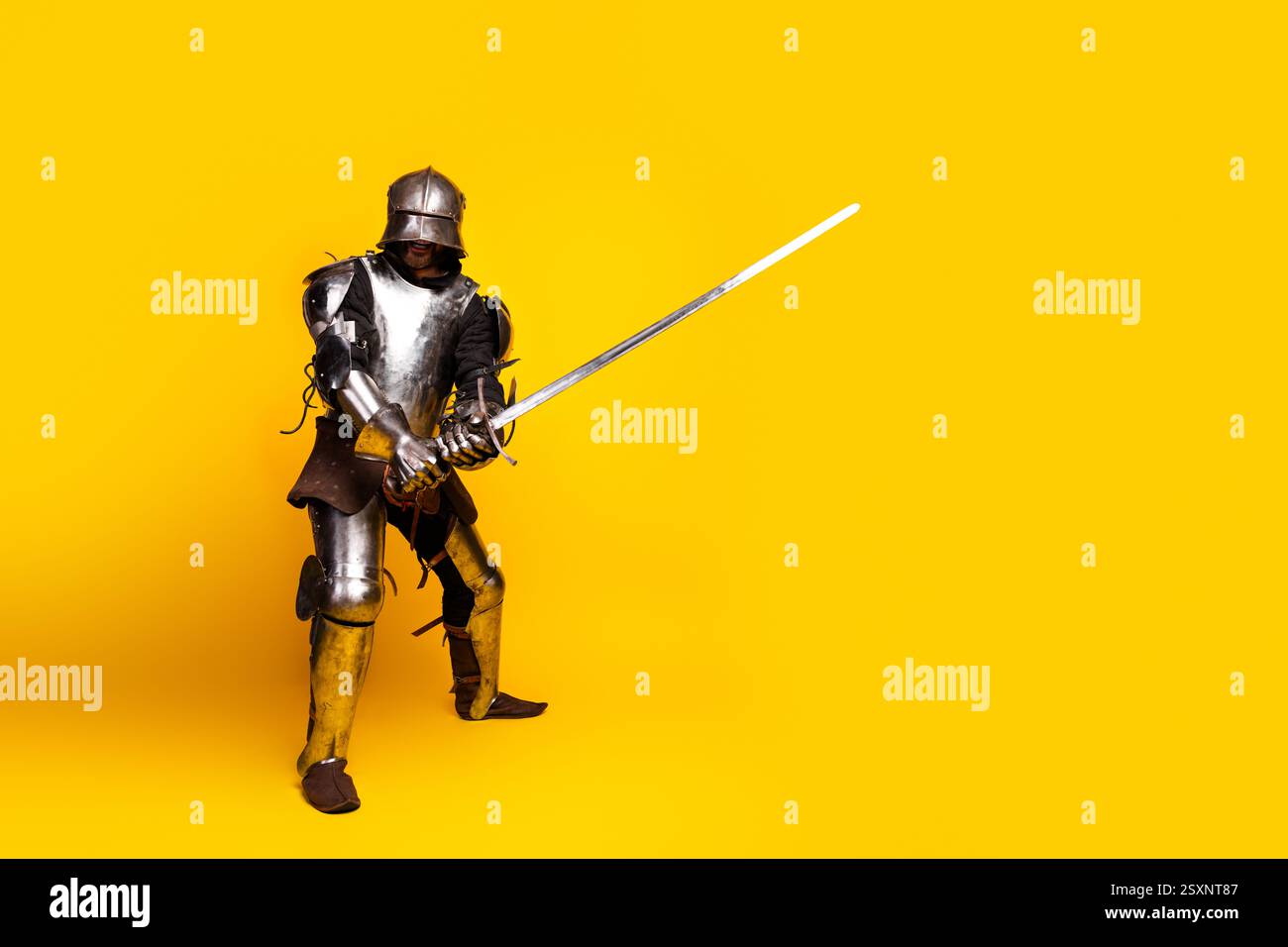 Strong knight in medieval armor with sword on bright yellow background ...