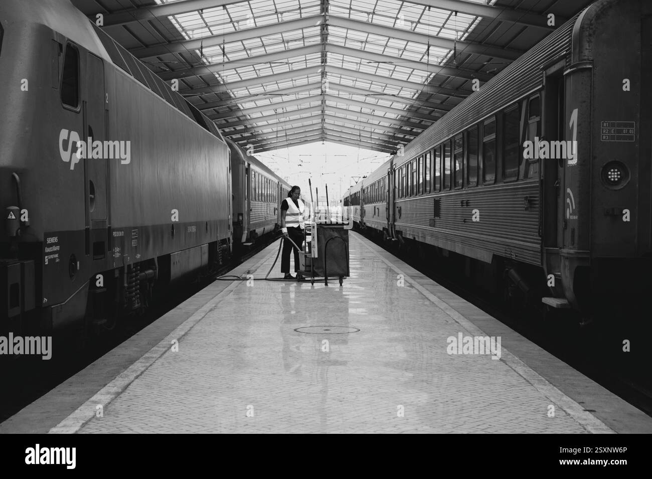 A worker cleans the platform between two trains at Santa Apolónia ...