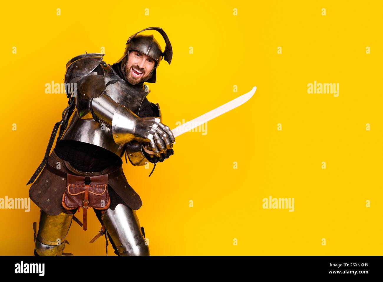 Young man dressed as a medieval knight posing with a sword in front of ...
