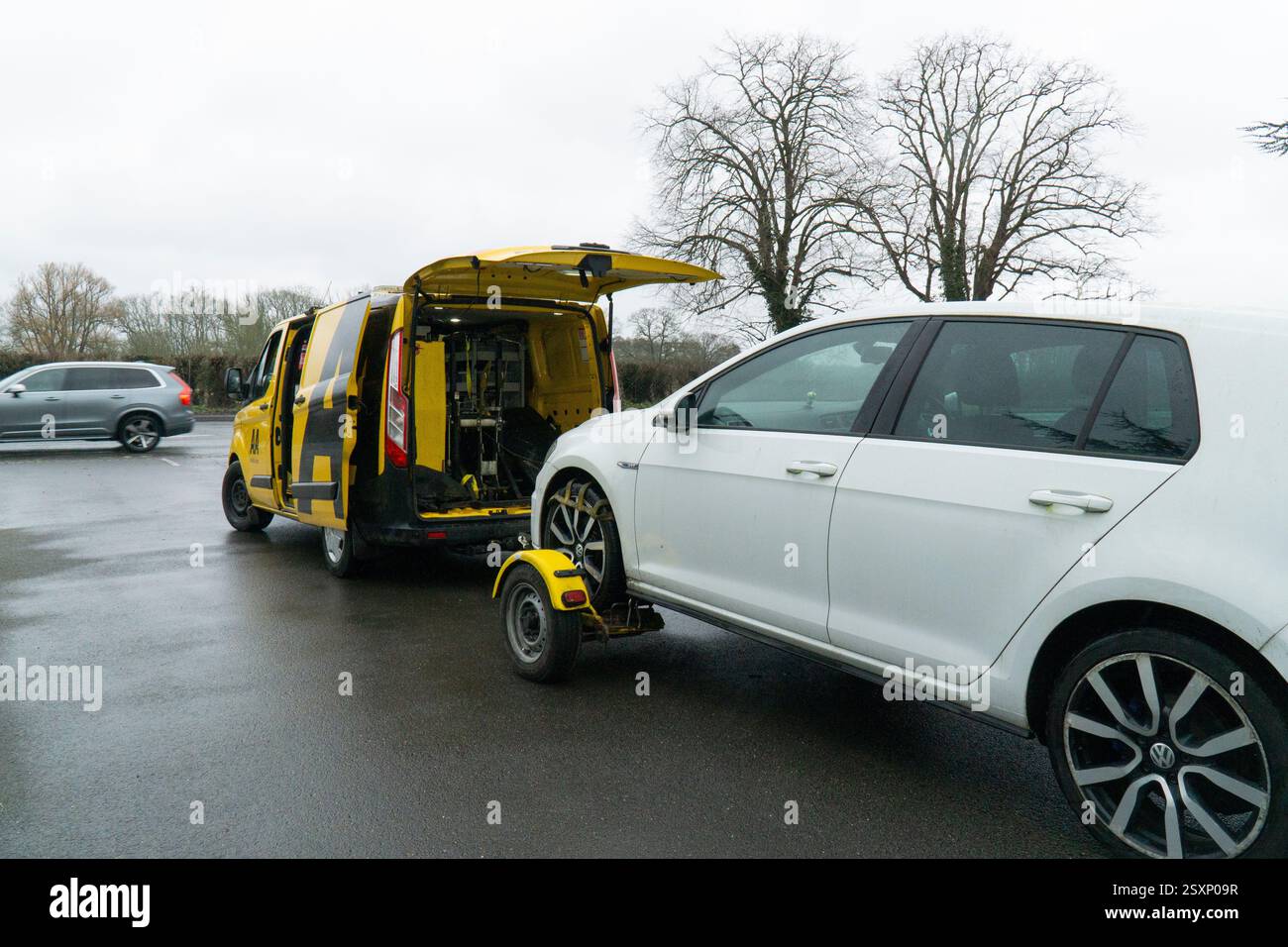An AA van prepares to tow a white VW Golf GTE that has broken down with ...
