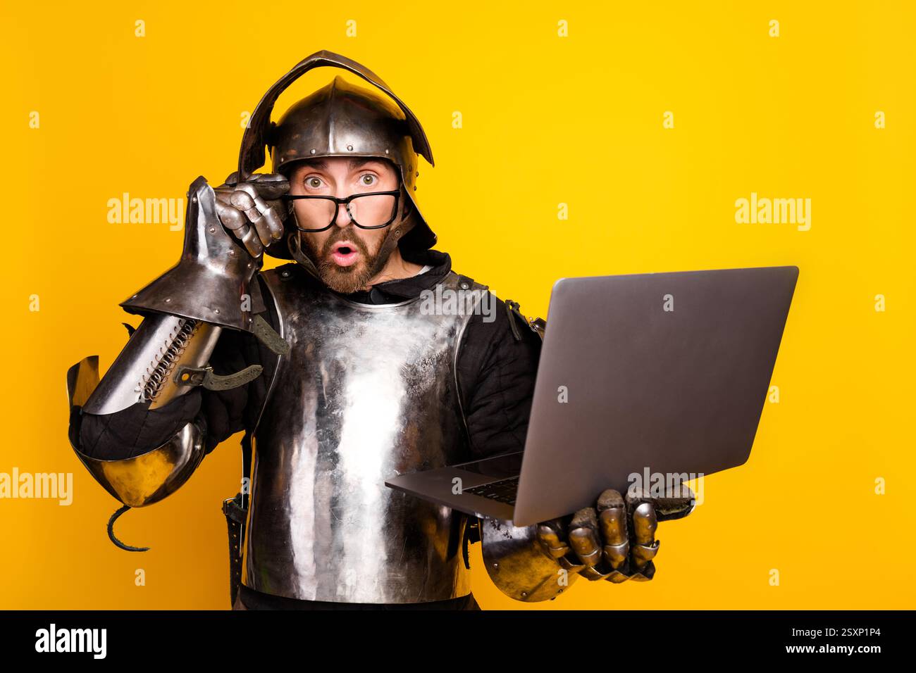 Young man in medieval knight armor using a laptop against vibrant ...