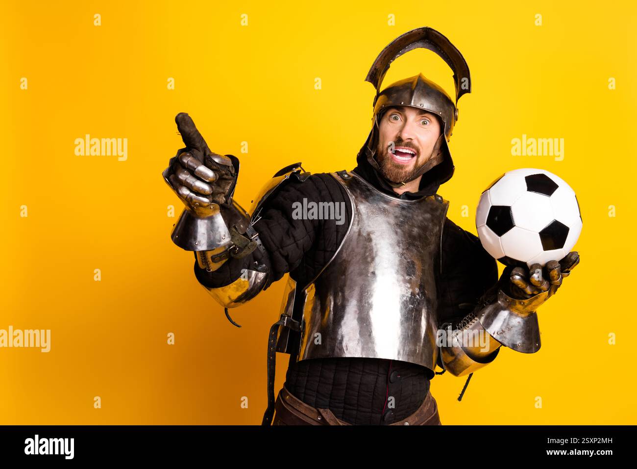 Knight in armor holding a soccer ball with a bright yellow background ...