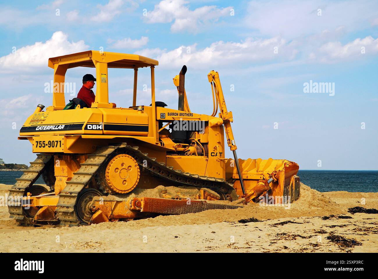 A bulldozer operator works to repair a damaged shore at Hampton Beach ...